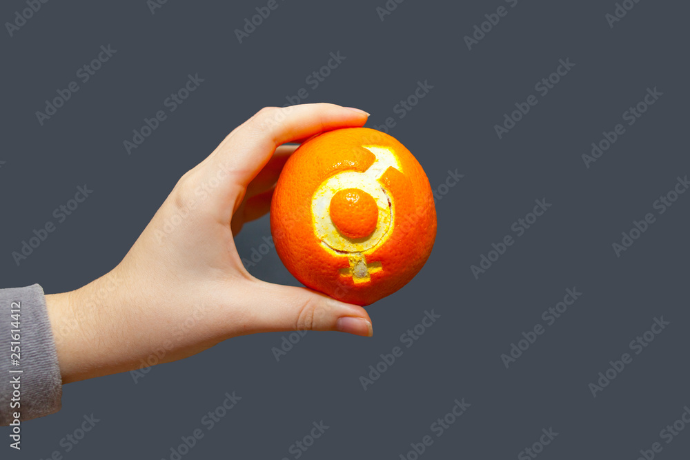 Gender equality. Orange with the sign of gender equality in the hand of ...