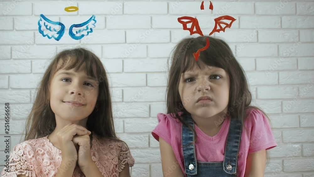 Angel and demon. An evil and kind child. Two little girls, one has ...