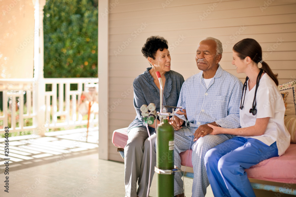 Senior man with nasal tubing sitting on the deck of rest-home with his ...