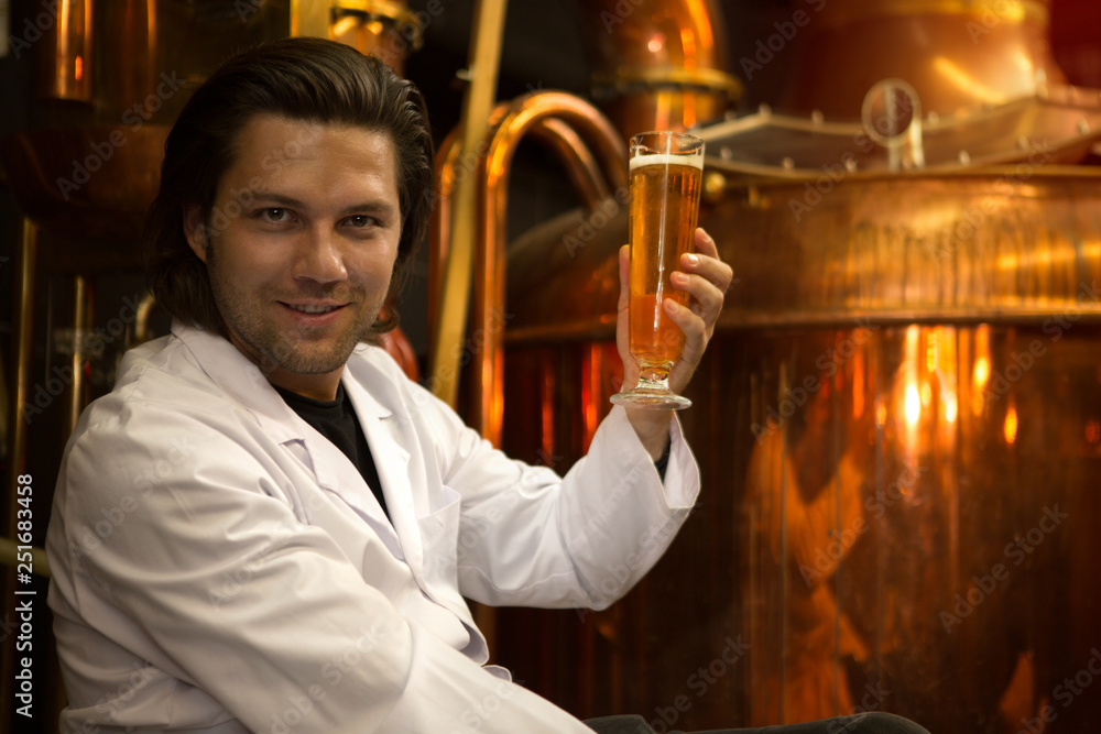 Cheerful worker of brewery smiling, looking at camera and posing with ...