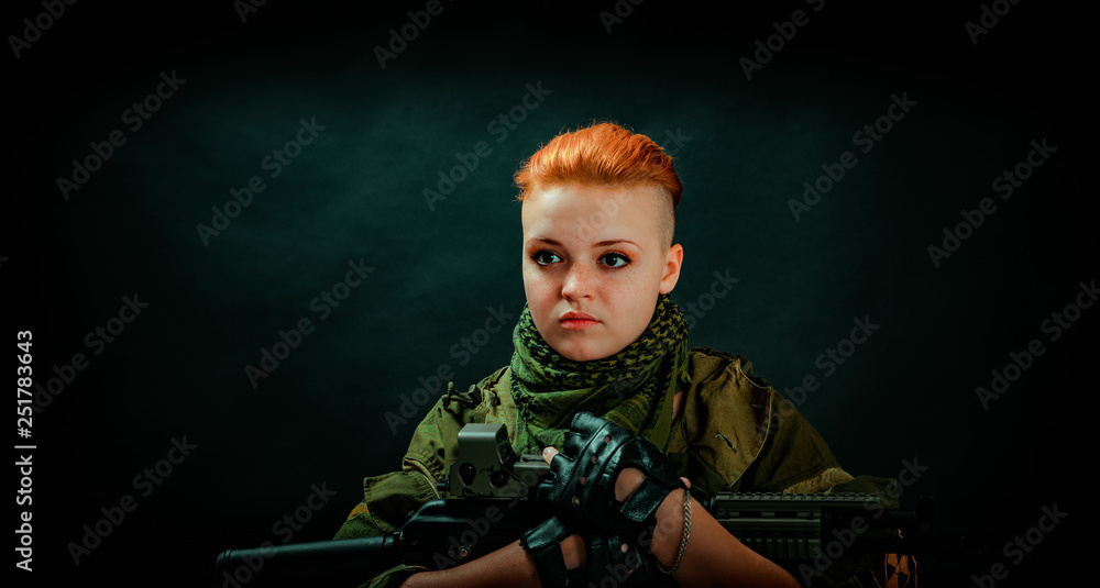 Woman with red hair in military uniform hold machine gun on her hands ...