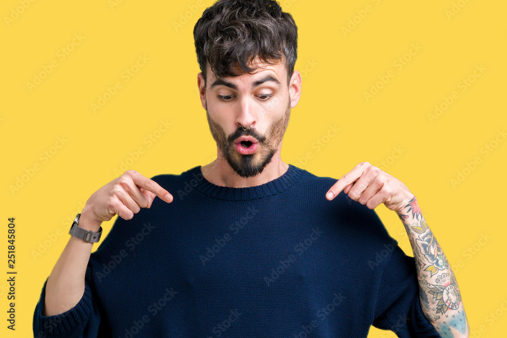 Young handsome man over isolated background Pointing down with fingers ...