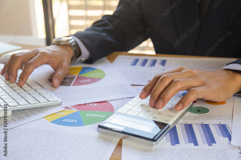 Businessman or accountant working on calculator to calculate business ...