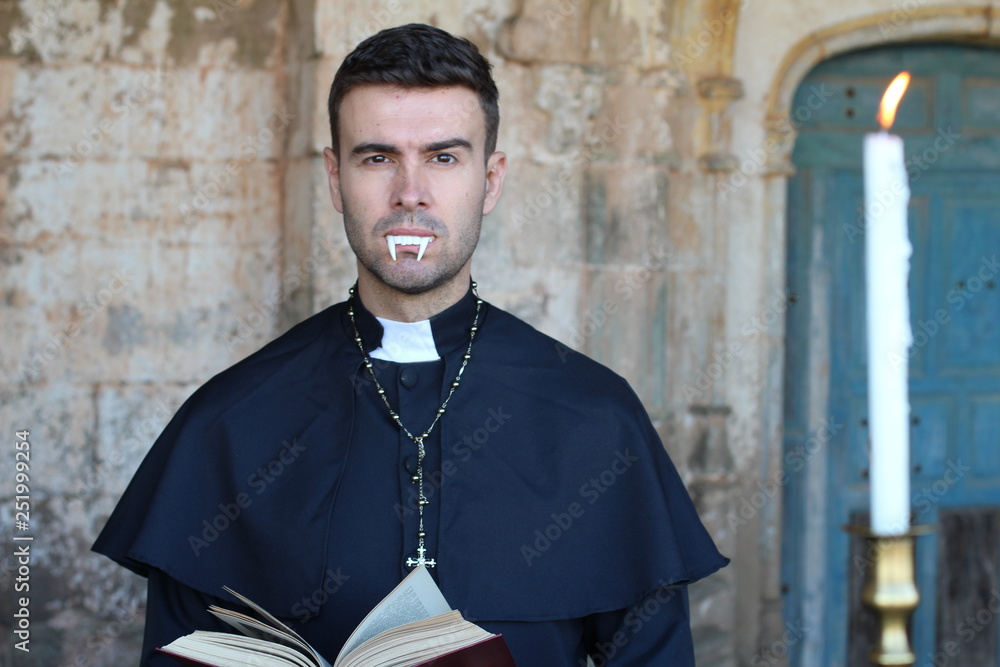 Spooky handsome priest with fangs Stock Photo | Adobe Stock