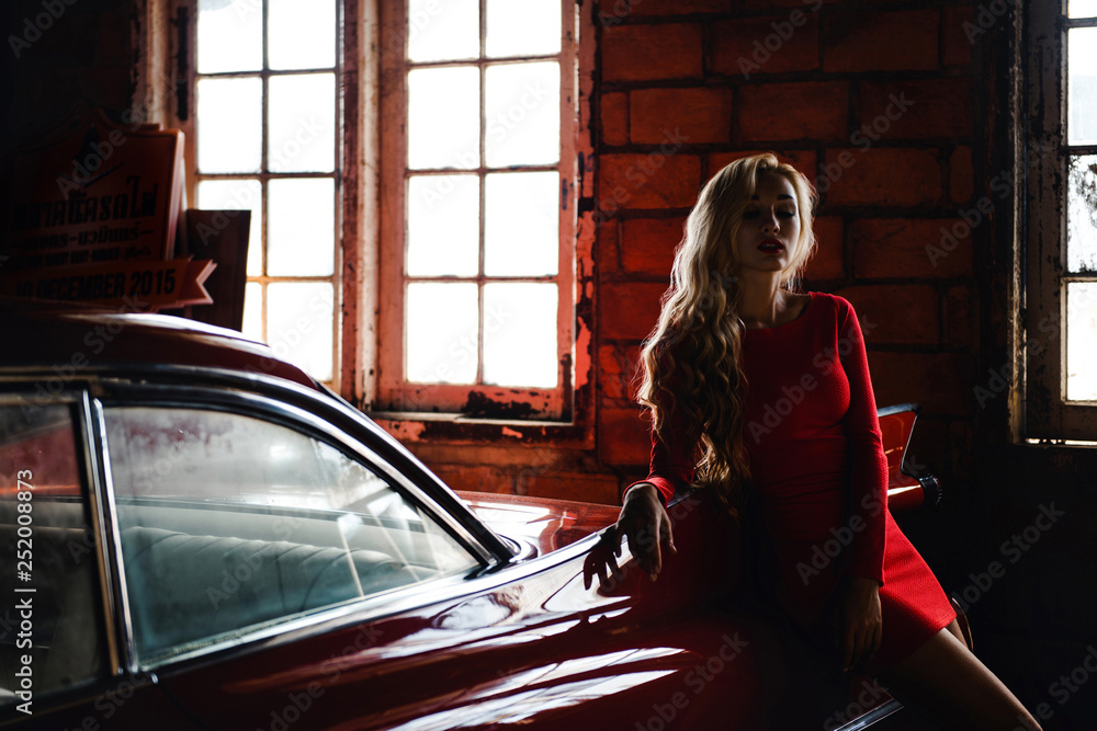 Sexy blond woman in red dress near retro car. Young sensual model ...