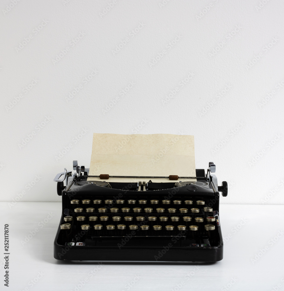 Old retro vintage black typewriter in black laid on white desk in front ...