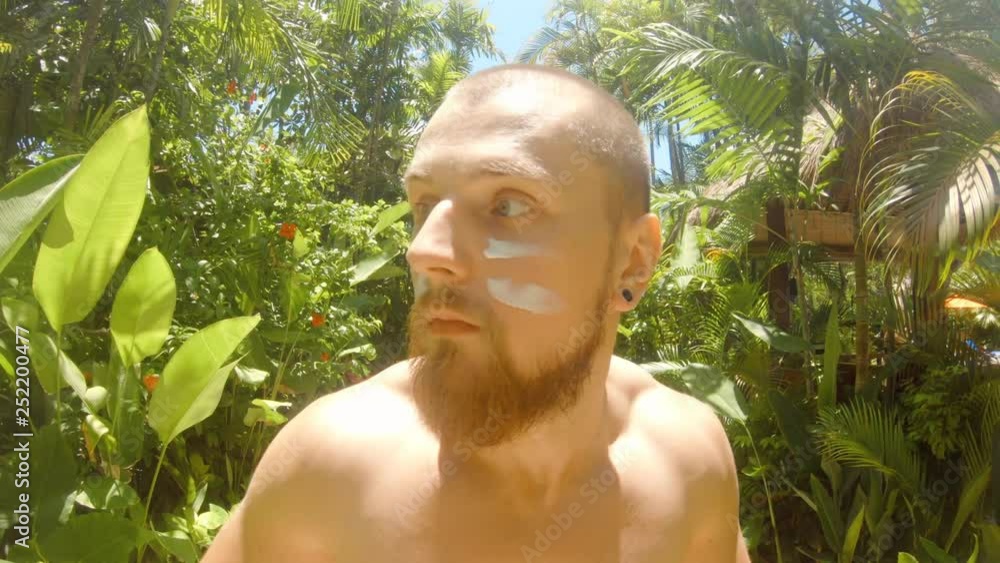 Young Bearded Man Applying Sunscreen Cream on Face Skin. Funny Vacation ...