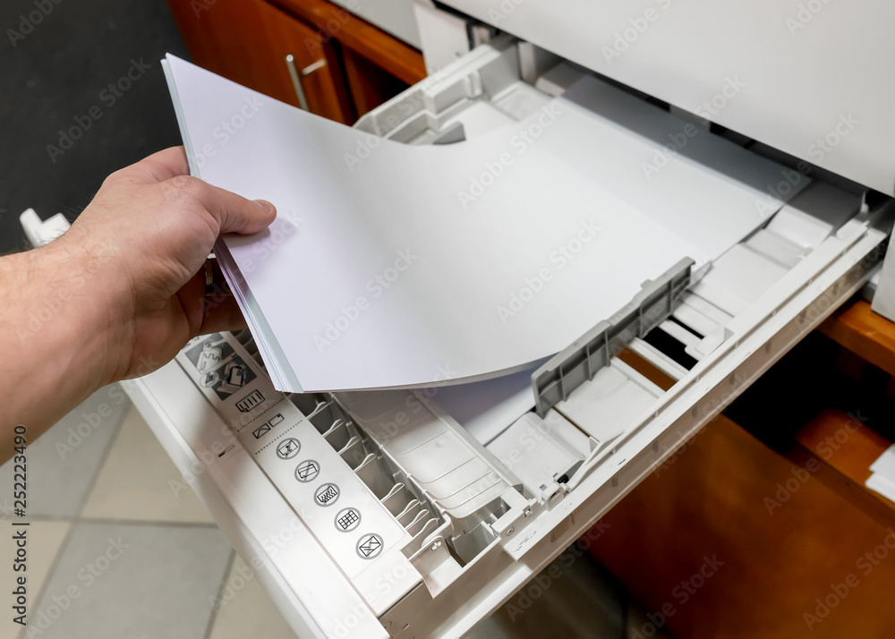 paper in printer. sets the paper stack in the laser printer. Stock ...