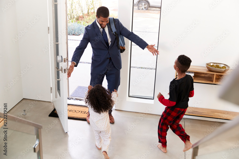 Children Greeting And Hugging Working Businessman Father As He Returns ...