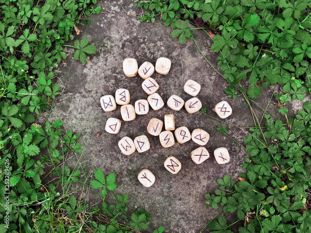 A stack of wooden runes at forest. Wooden runes lie on a rock ...