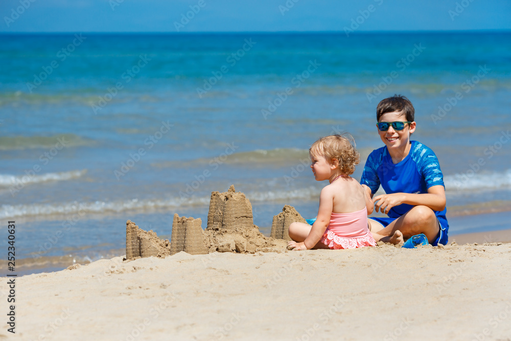 Fotografia do Stock: Kids playing on a beach. Two children build a sand ...