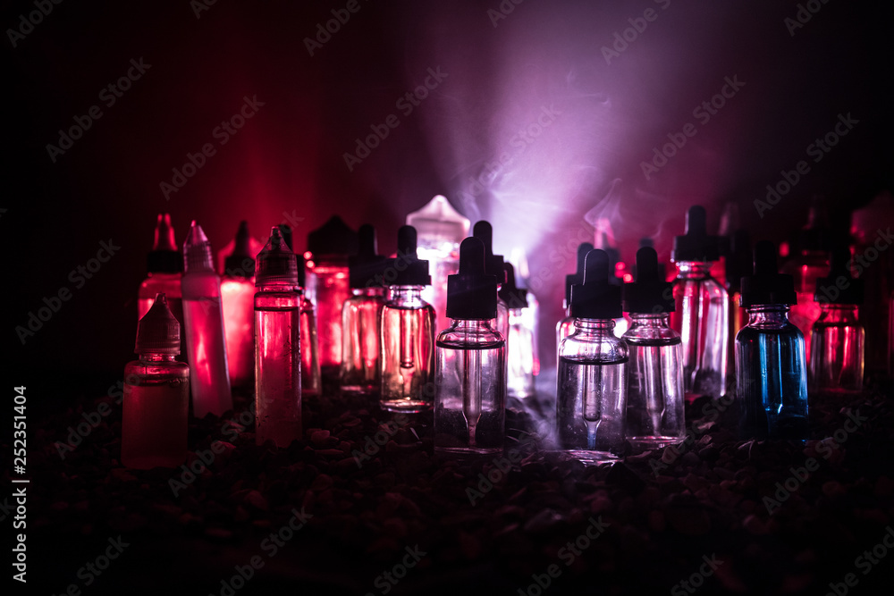 Vape concept. Smoke clouds and vape liquid bottles on dark background ...