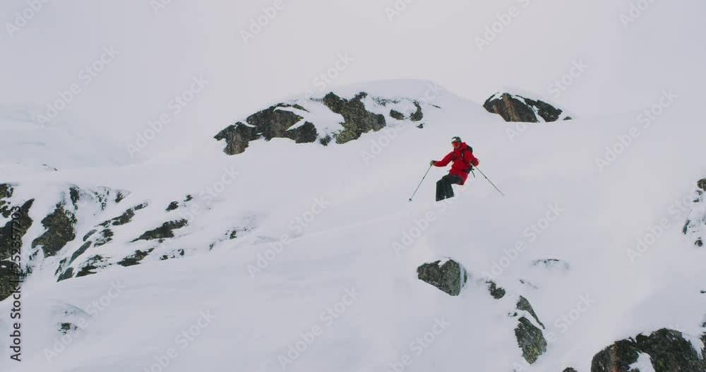 Skier doing powder turn and jumping off of ice cliff, extreme ...