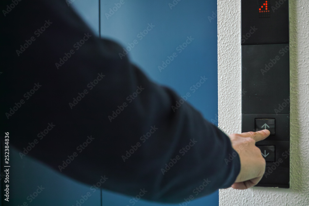 Poster A rear view of a man pushing an elevator button – Wall Art ...