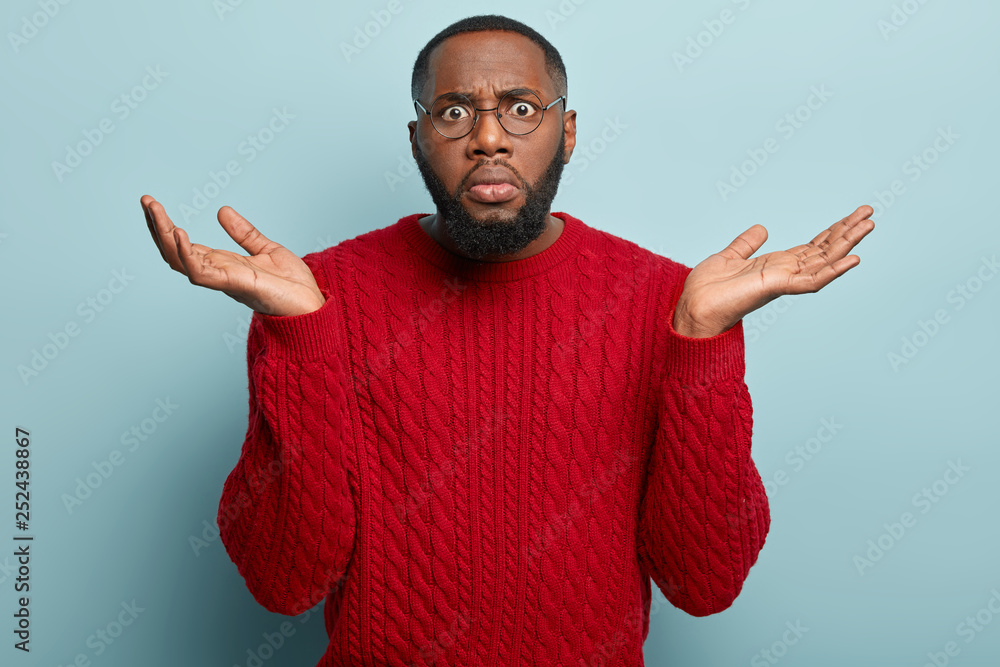 Angry disappointed black man spreads hands with indignation, looks with ...
