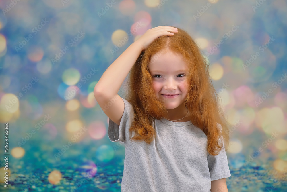 Concept portrait of a cute pretty child girl with red hair on a color ...