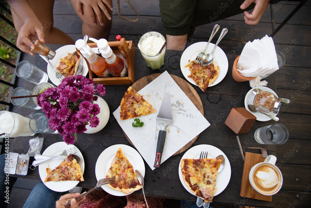Pizza time. Top of pizza and drinks on the table, with a group of ...
