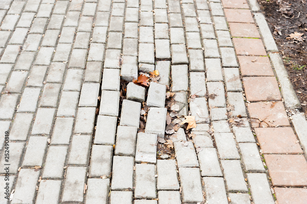 Dangerous hole for pedestrians on damaged sidewalk with broken bricks ...