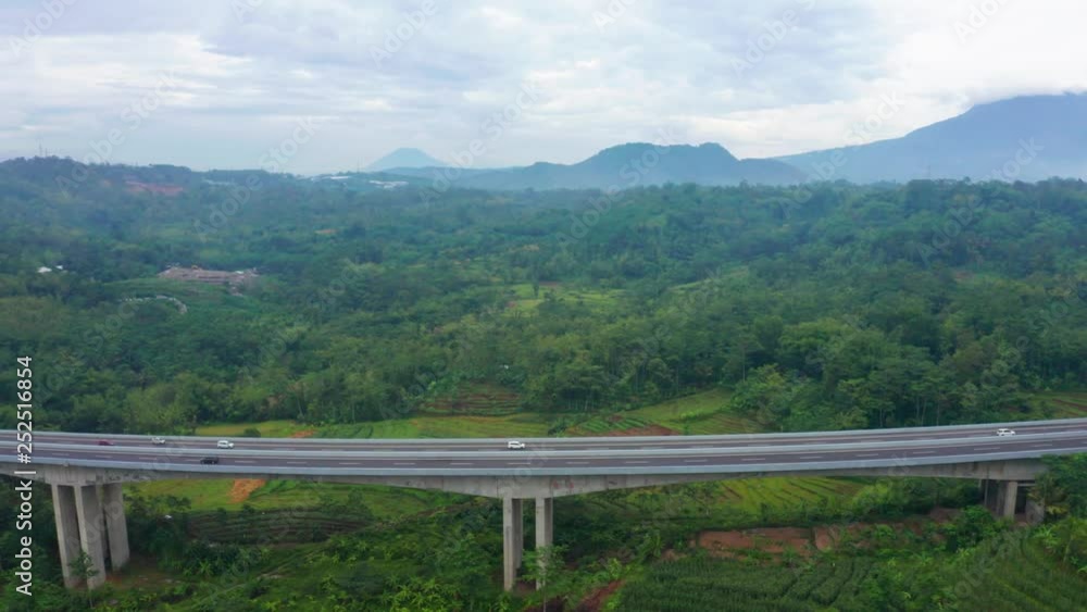 Aerial view of fast traffic on Trans-Java Toll Way bridge with green ...