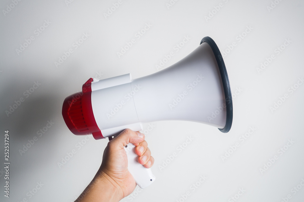 mégaphone avec une main qui le tient Stock Photo | Adobe Stock