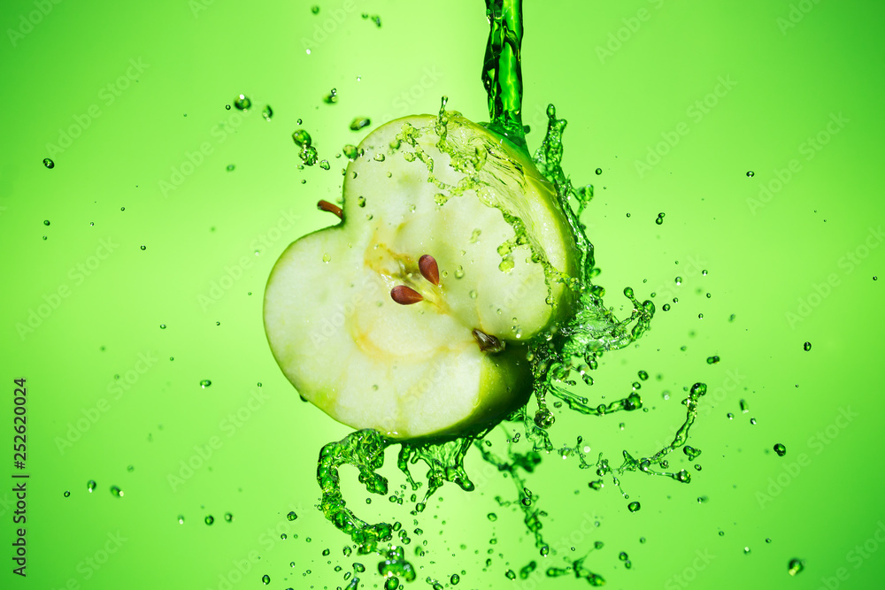 Apple splashing juice, water, on a green background. Stock Photo ...
