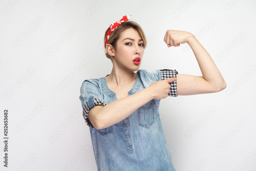Portrait of strong proud beautiful young woman in casual blue denim ...
