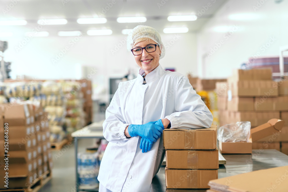 Smiling Caucasian blonde female employee in sterile uniform and with ...