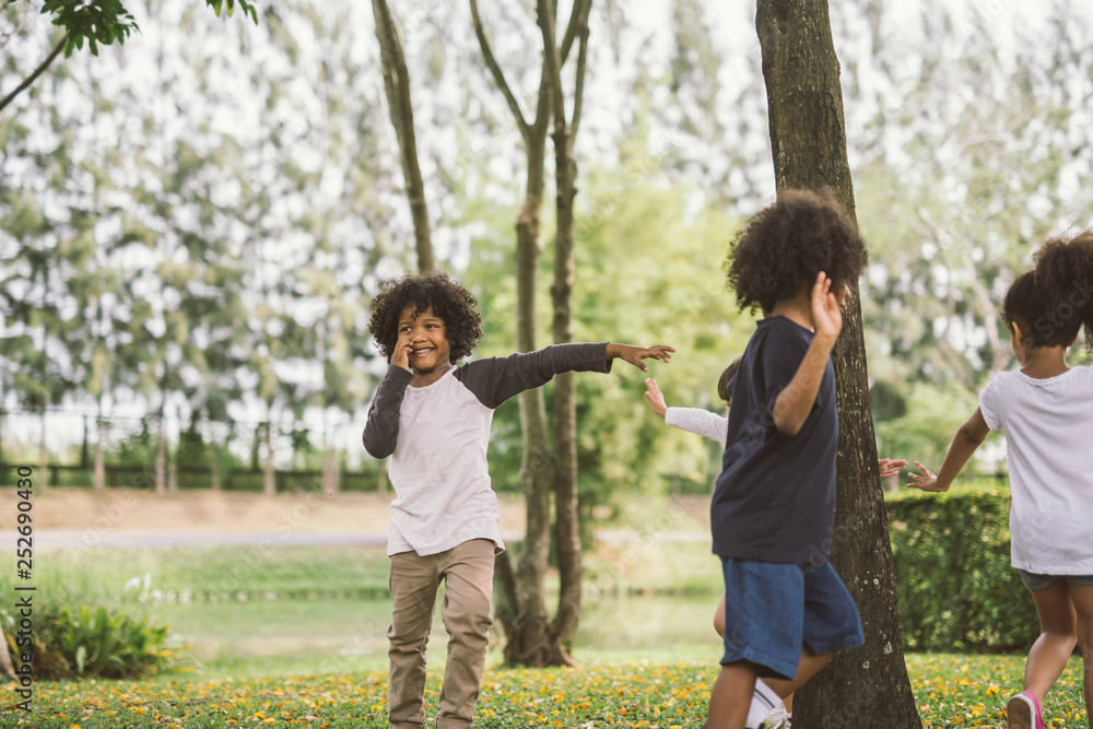 kids playing outdoors with friends. little children play at nature park ...