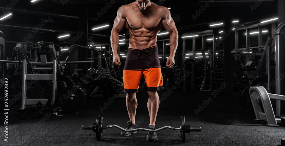 Attractive tall muscular bodybuilder doing heavy deadlifts in moder ...