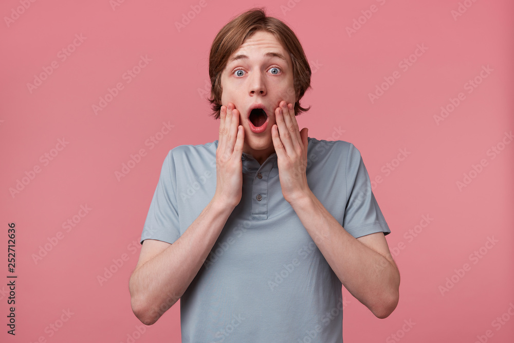 Close up of young man with blown away, amazed expression and dropped ...