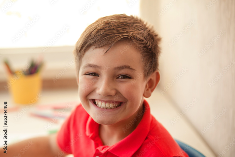 cute happy brunette child 9-10 years old in red shirt drawing at home ...