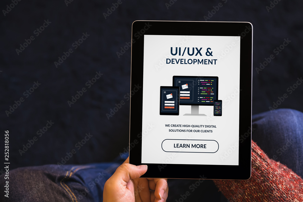Hands holding tablet with UI/UX design and development concept on ...