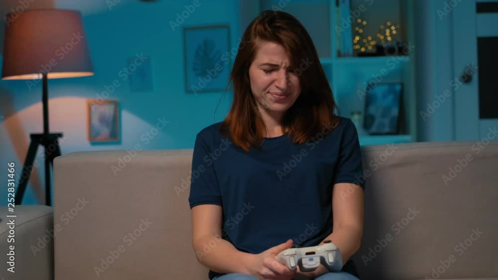 Vidéo Stock Sad girl loses the video game at home at night. Excited ...