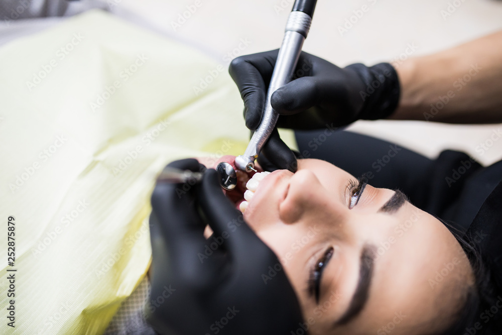 Young man dentist working in the modern dentist office, doing teeth ...