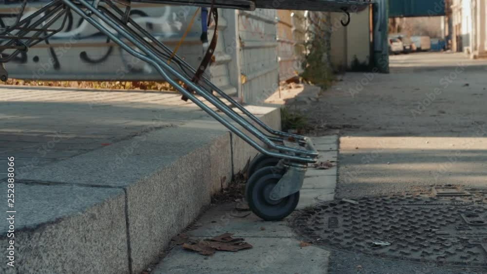 Homeless man out on the streets with his belongings in a trolley. Bum ...