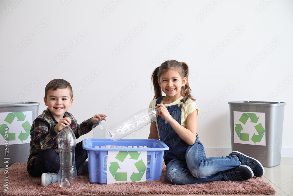 Little children sorting garbage near white wall. Concept of recycling ...