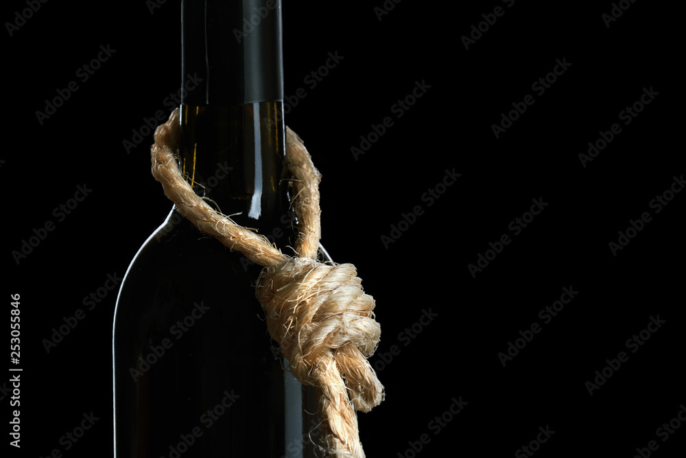 Alcohol abuse concept. A bottle of a vine with a rope loop on the neck ...