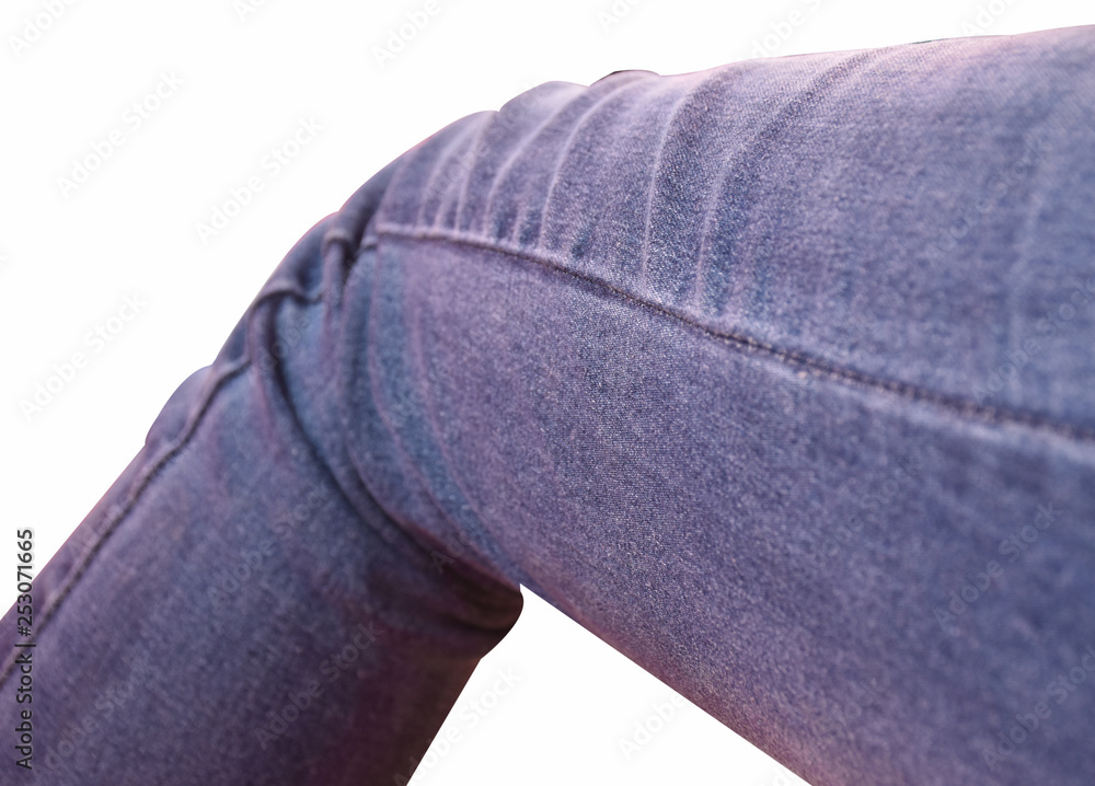 Focus a girl left leg in jean pants on white background. A girl is ...