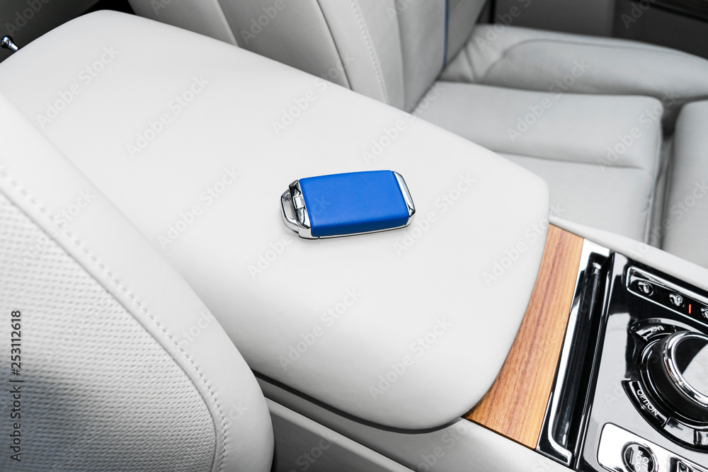 Closeup inside vehicle of wireless blue leather key ignition on natural ...