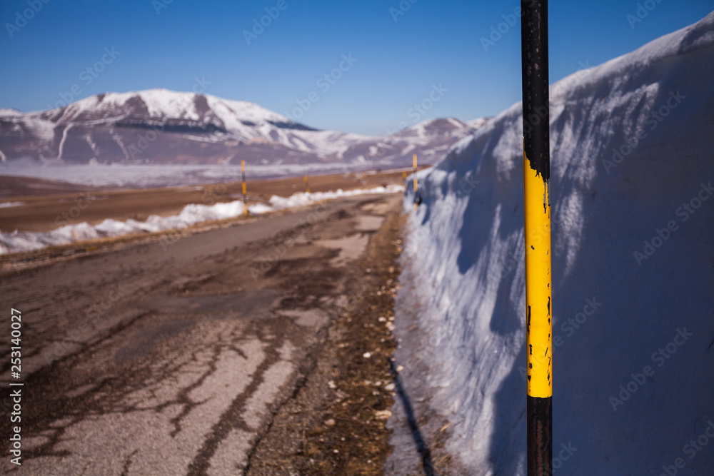 Road sign in the snow on the road to arrive in Castelluccio di Norcia ...