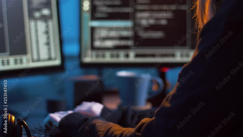cybercrime, hacking and technology concept - female hacker in dark room creating code or using ...