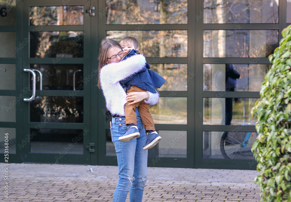 Emotional tween girl holding and hugging her little baby brother ...