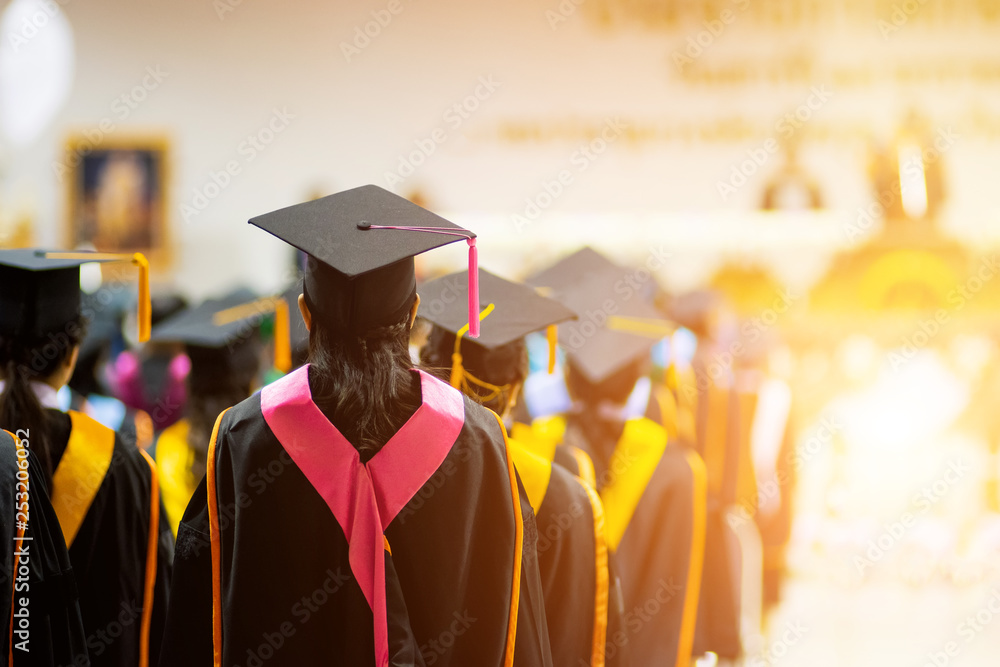 Rear view selective focus of the university graduates crowded in the ...