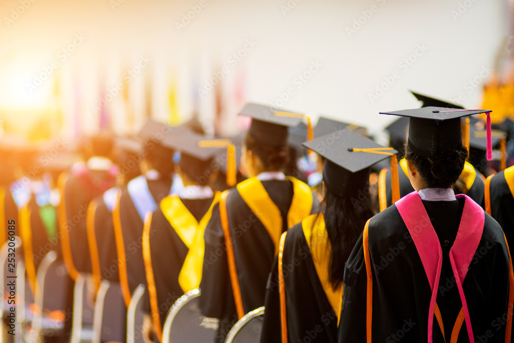 Rear view selective focus of the university graduates crowded in the ...