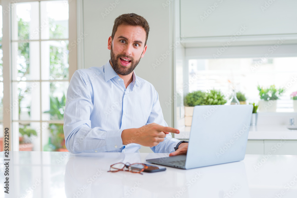 Handsome business man working using computer laptop very happy pointing ...
