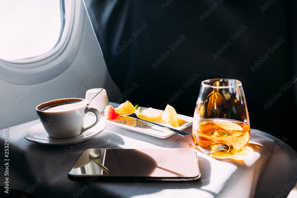passenger table in airplane with drinks, snacks and digital tablet ...