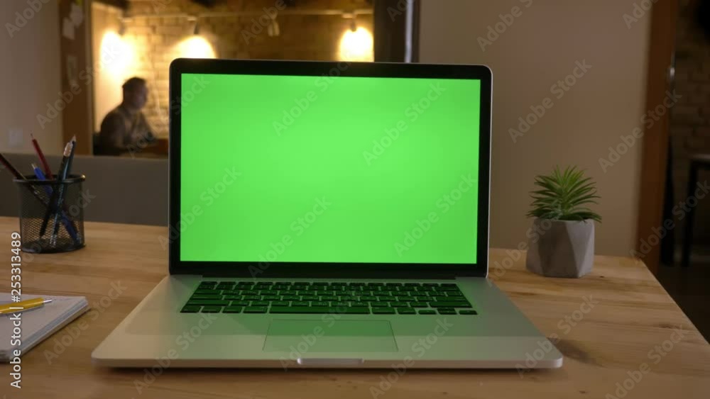 Closeup shoot of a green screen of the laptop lying on the desk in ...