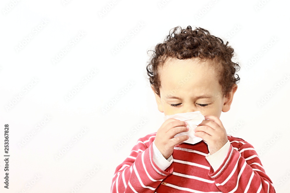child blowing nose after catching a cold with white background stock ...