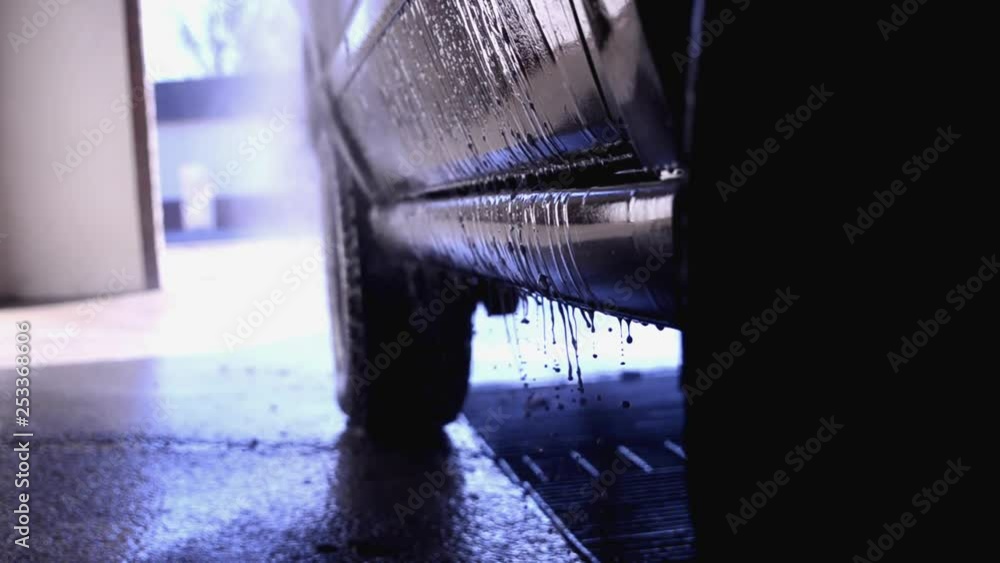 Using the wand sprayer at a car wash to clean off the door and bottom ...