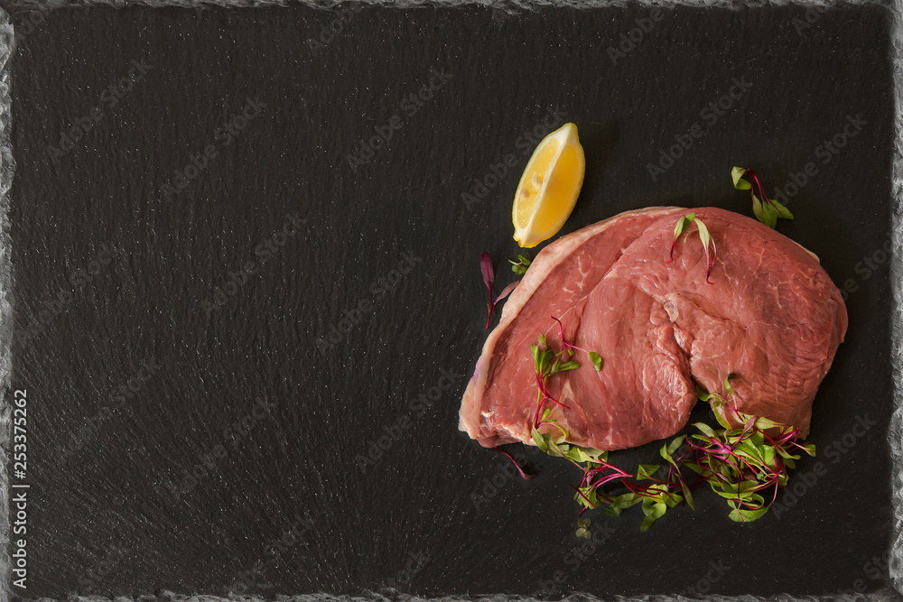 red meat rump beef steak fresh raw on a black background slate plate ...